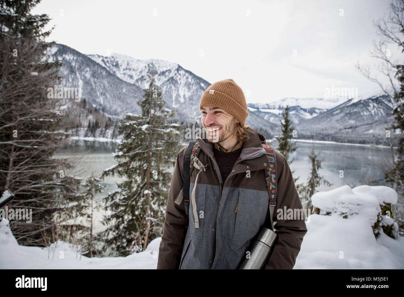 Happy man in alpine winter landscape with lake Stock Photo - Alamy