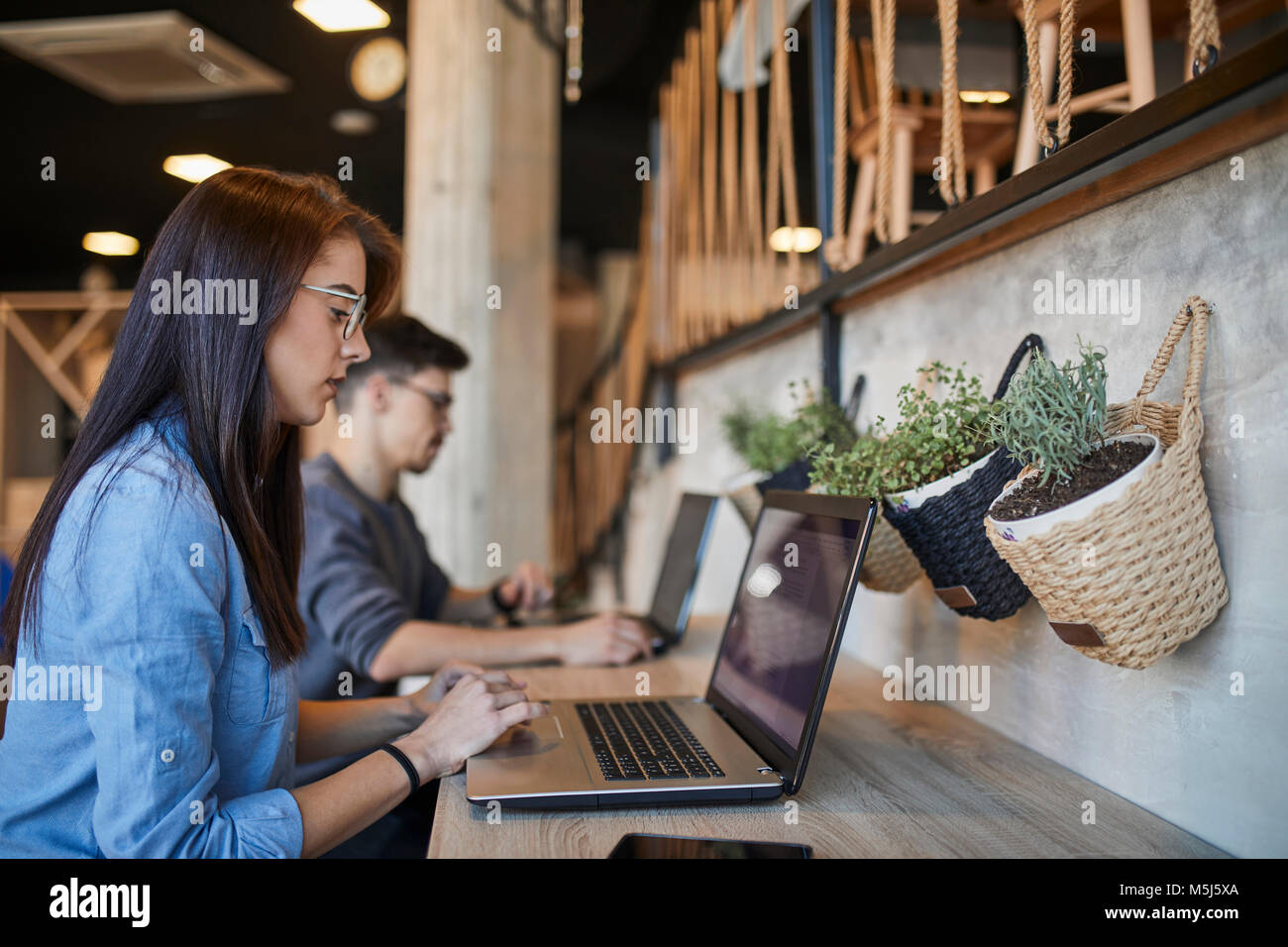 Young woman and man in a cafe using laptops Stock Photo - Alamy