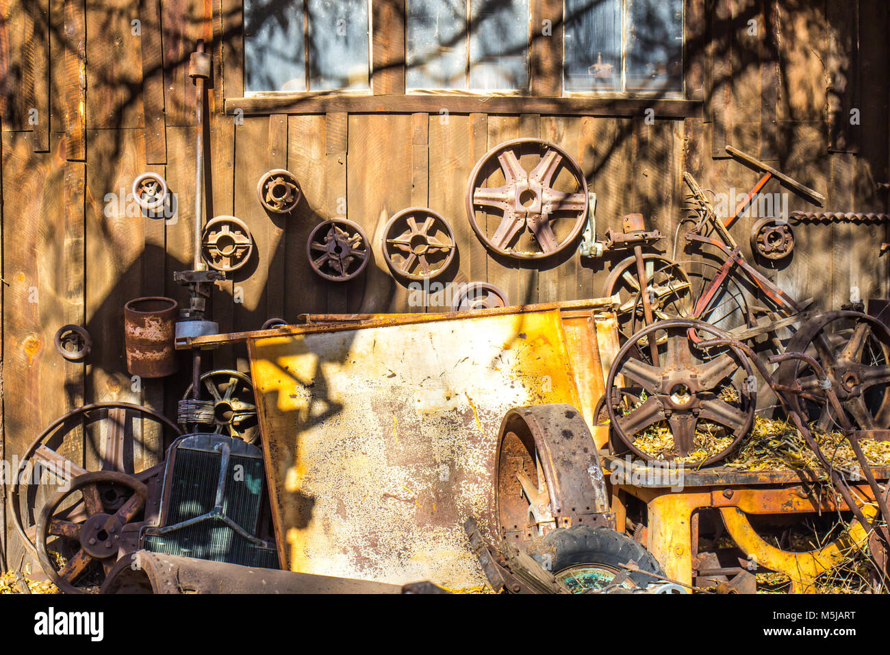 Assortment Of Metal Wheels On Building Wall Stock Photo - Alamy