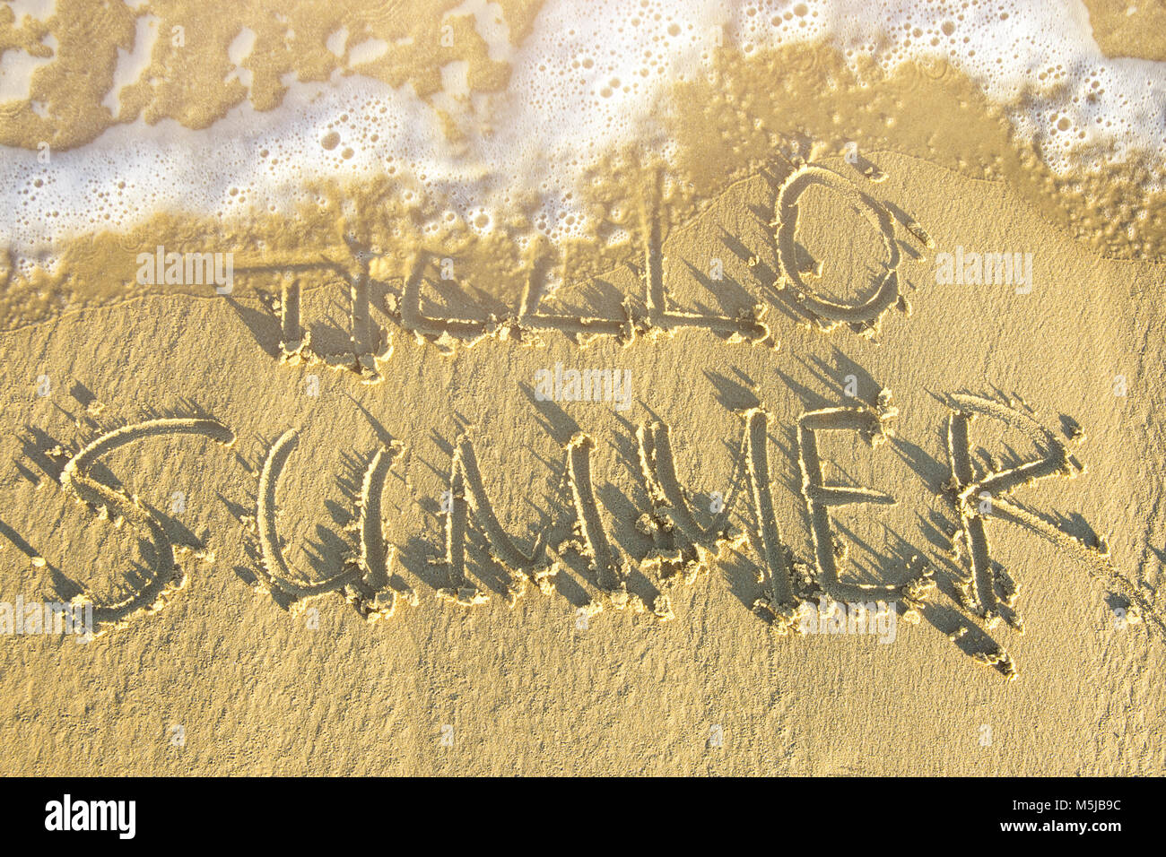 Hello Summer Text Written by Hand on Beach Sand Washed Away by Foamy ...