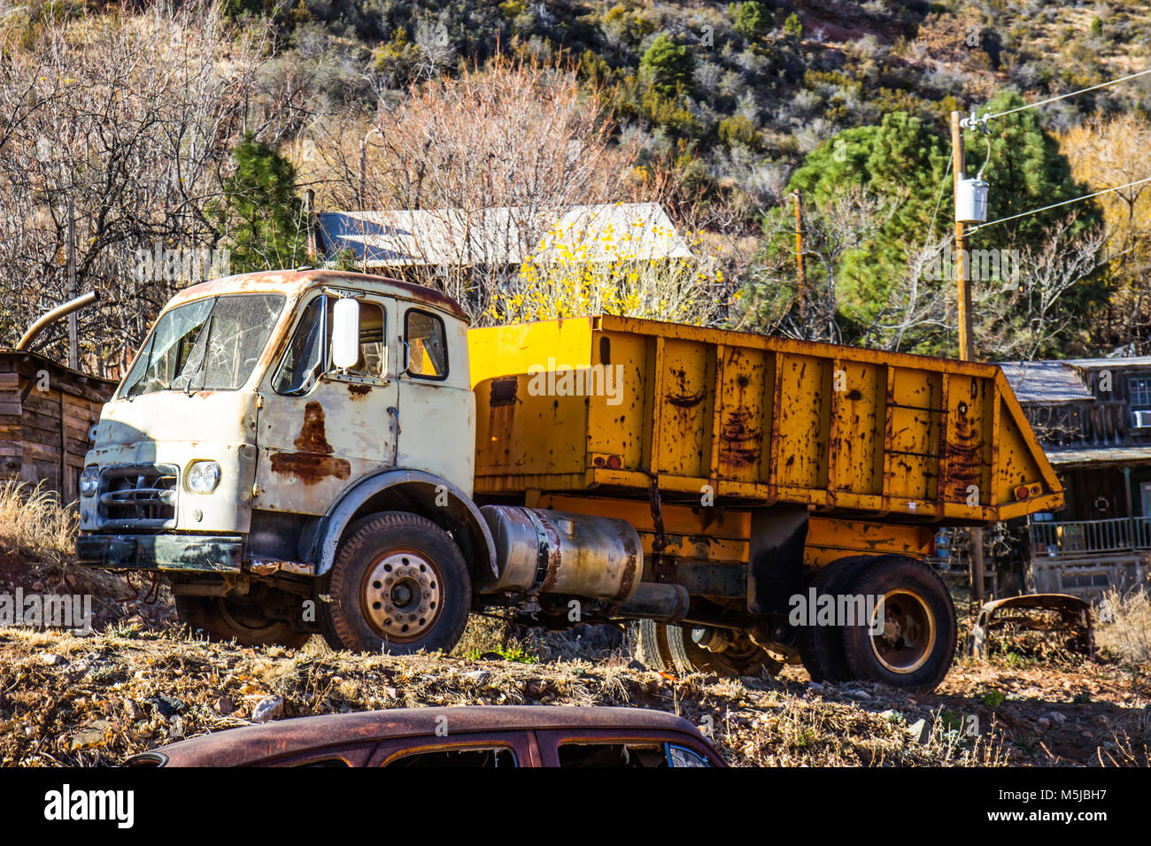 Vintage Yellow Rusty Dump Truck In Salvage Yard Stock Photo - Alamy