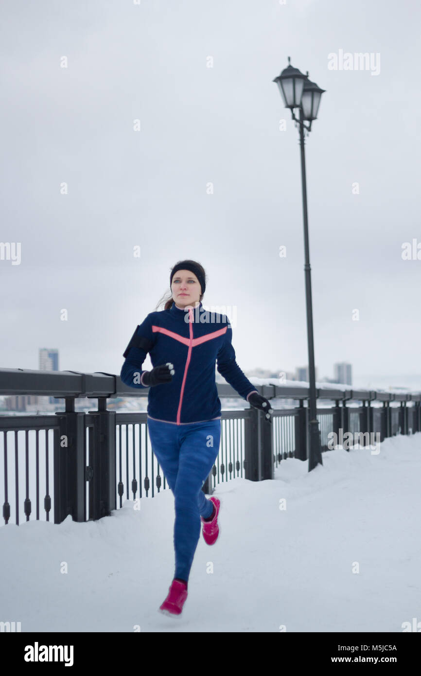 Fitness girl model running at snow outdoor, jogging Stock Photo - Alamy