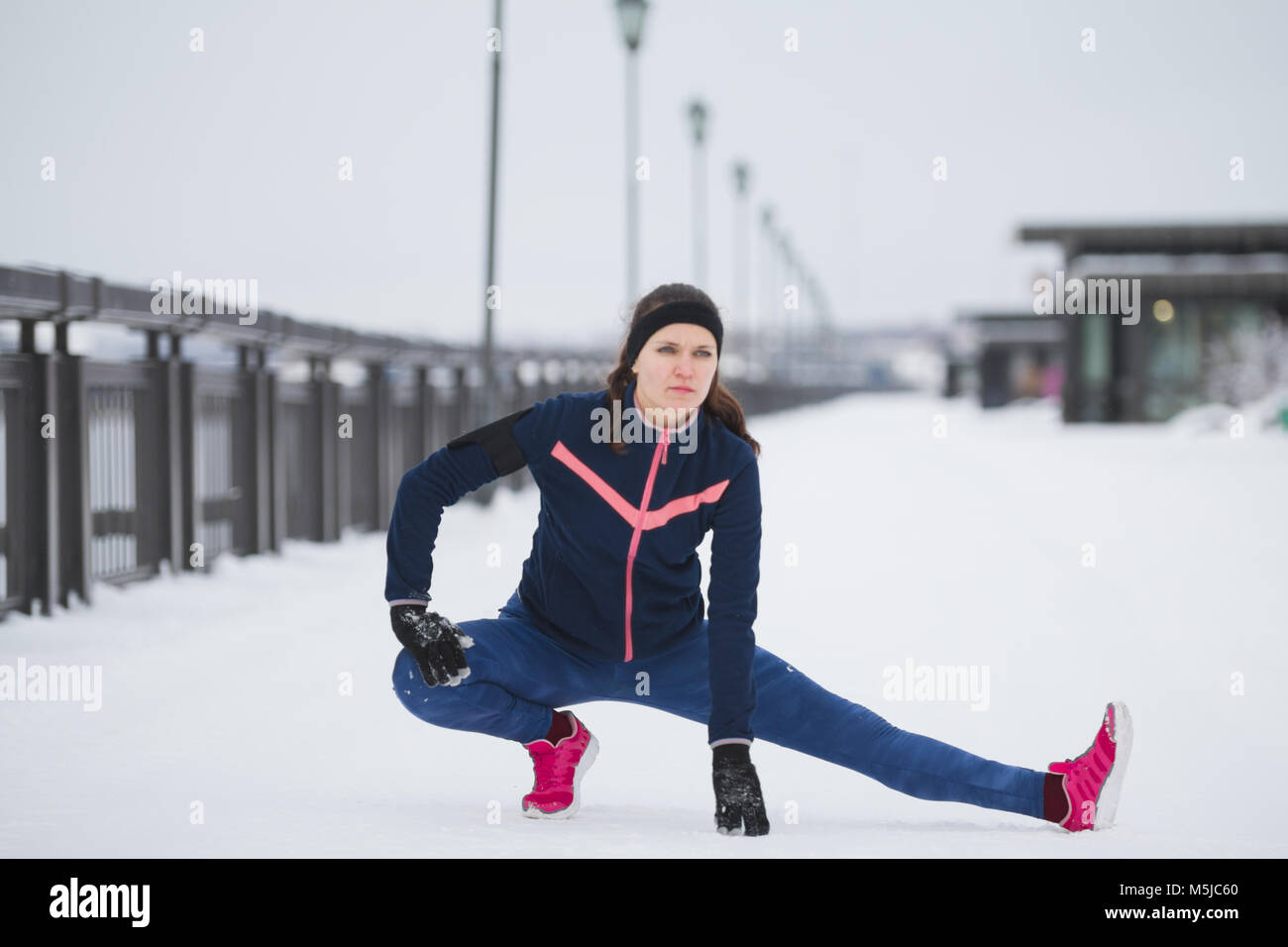 Fitness girl model runner doing flexibility exercise for legs before ...
