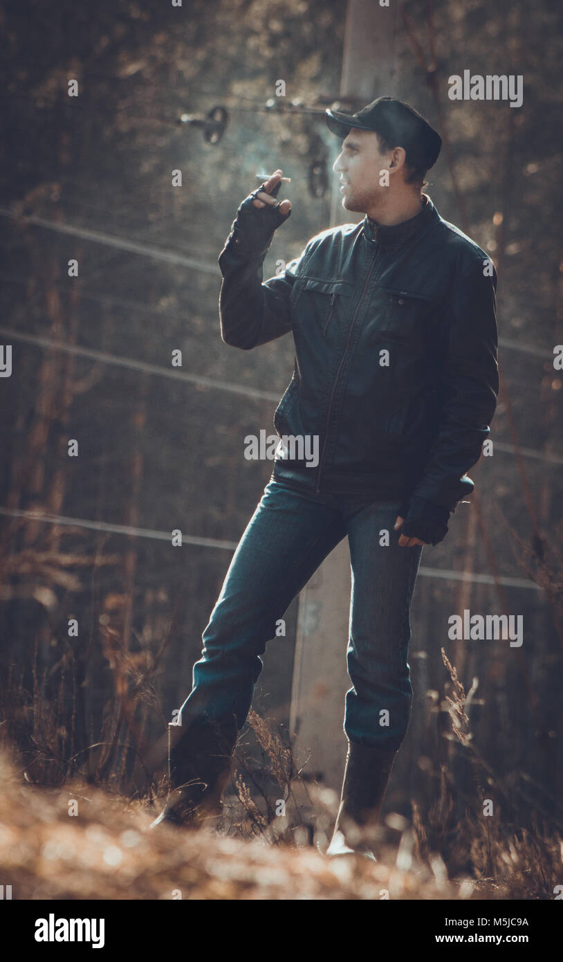Courageous man standing in forest and smoking Stock Photo - Alamy