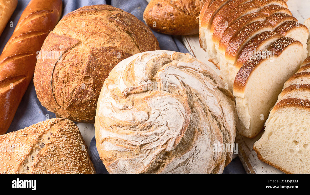 Mixed bread on white wooden table background. Top view Stock Photo - Alamy