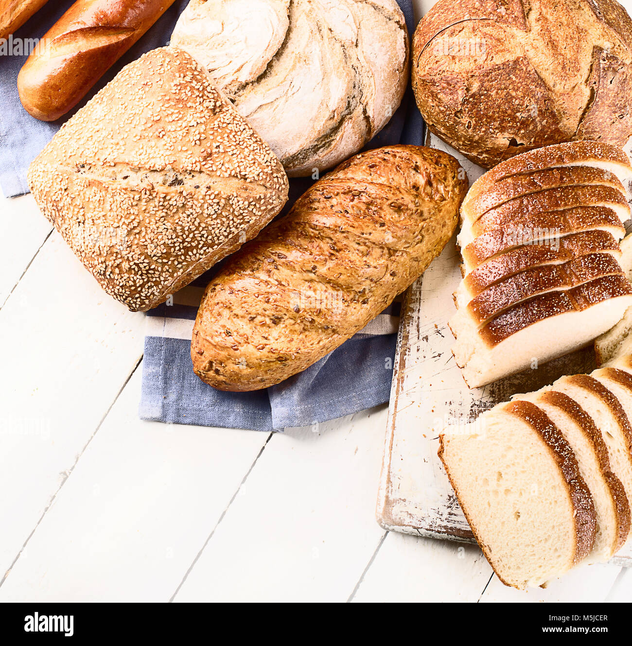 Mixed bread on white wooden table background. Top view Stock Photo - Alamy