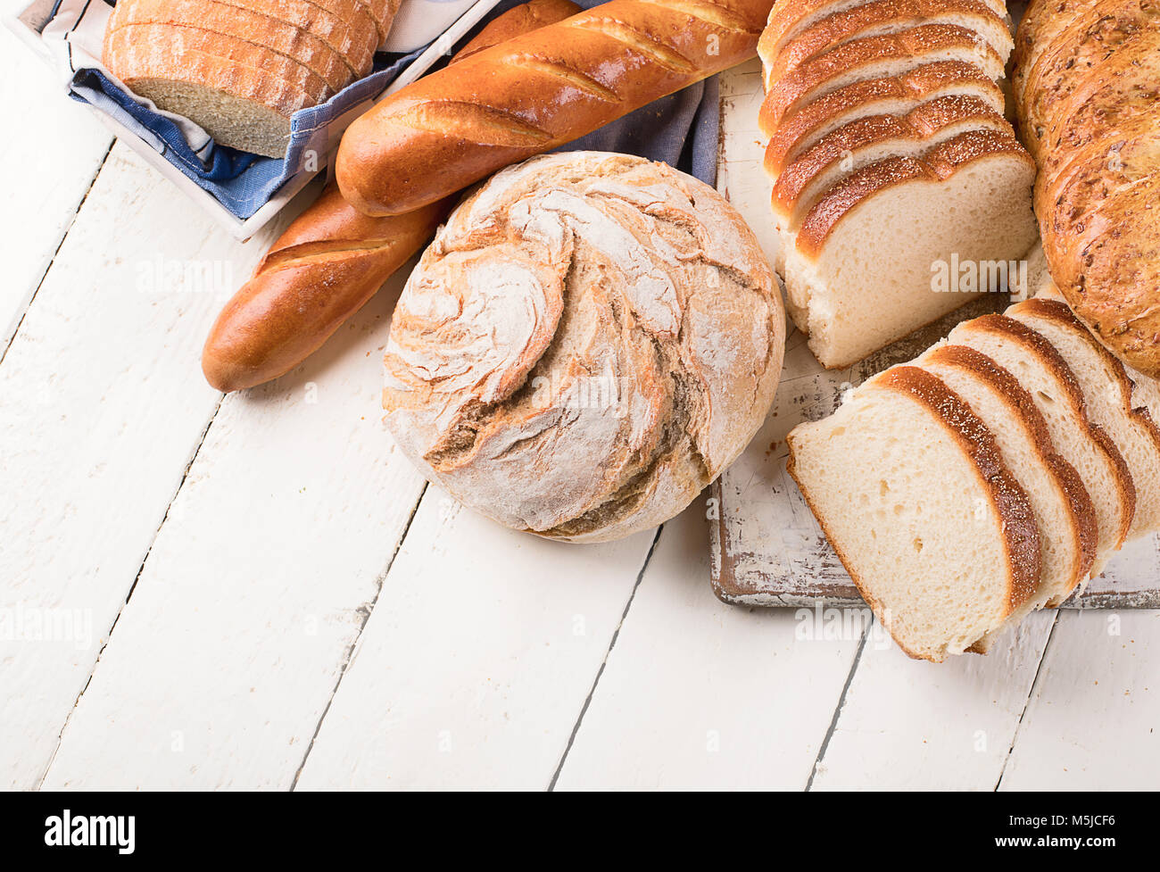 Mixed bread on white wooden table background. Top view Stock Photo - Alamy