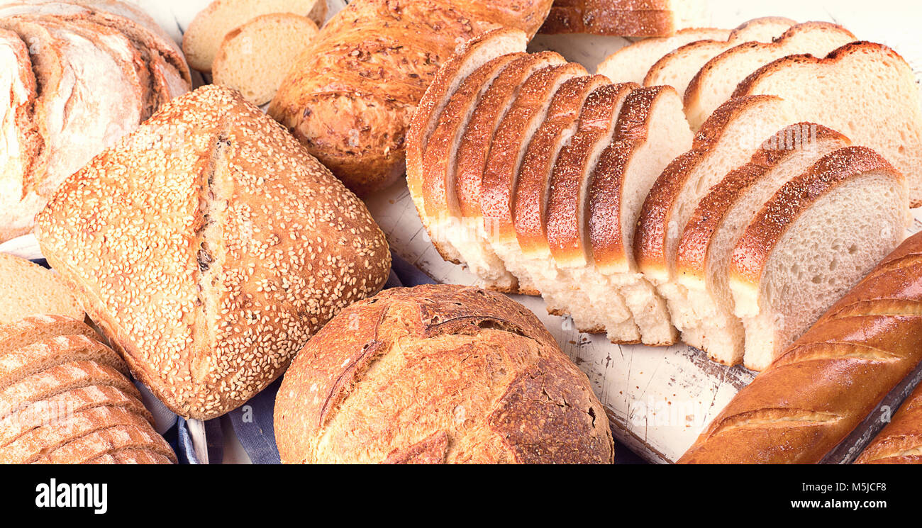 Mixed bread on white wooden table background. Top view Stock Photo - Alamy
