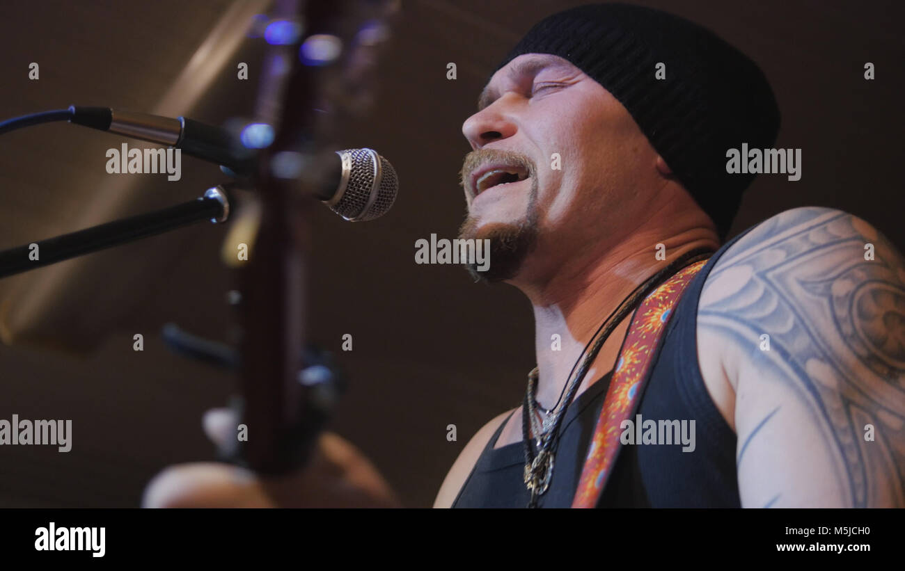 Muscular man musician plays guitar at rock-concert Stock Photo - Alamy