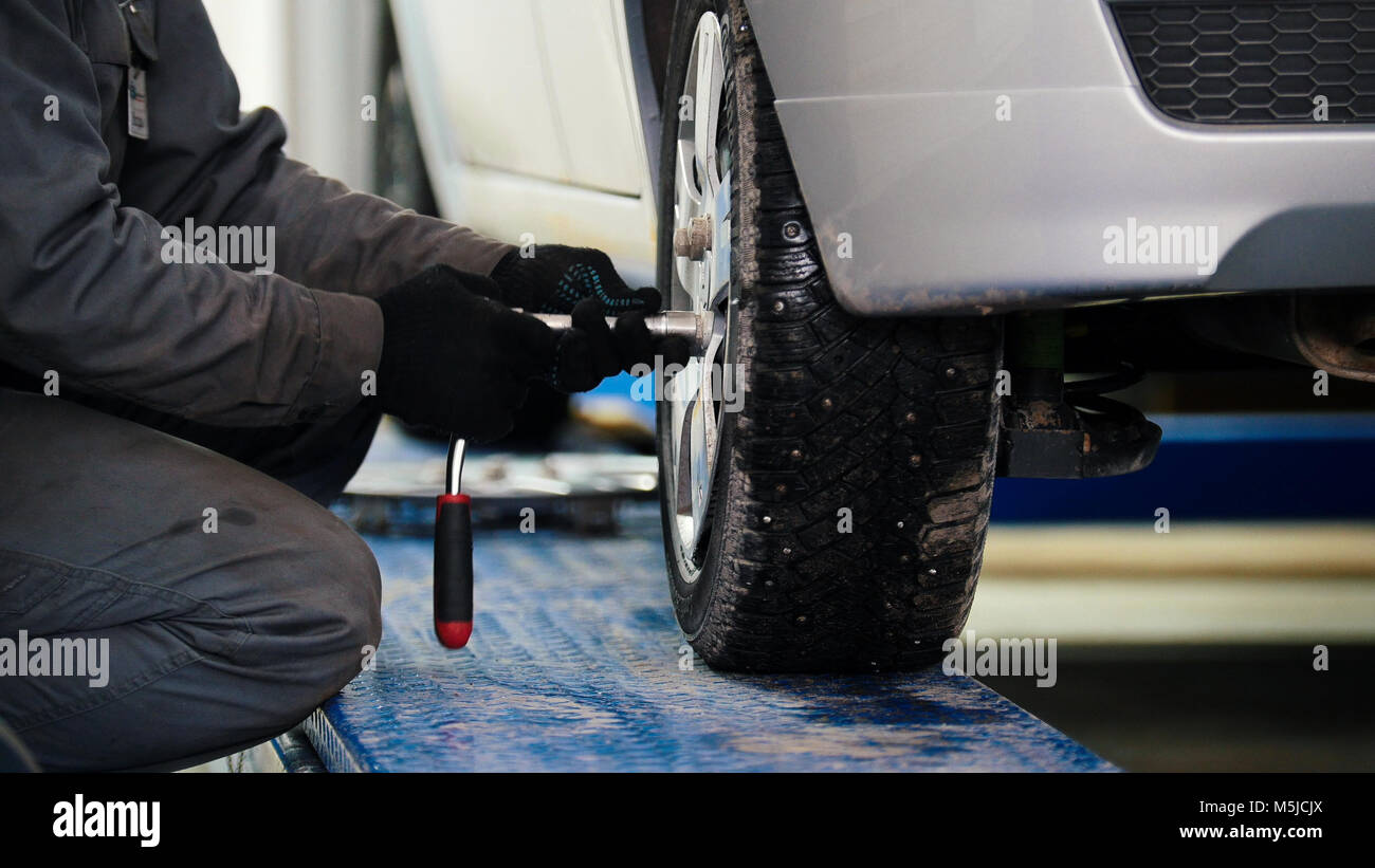 Car mechanic screwing pin automobile wheel in service Stock Photo - Alamy