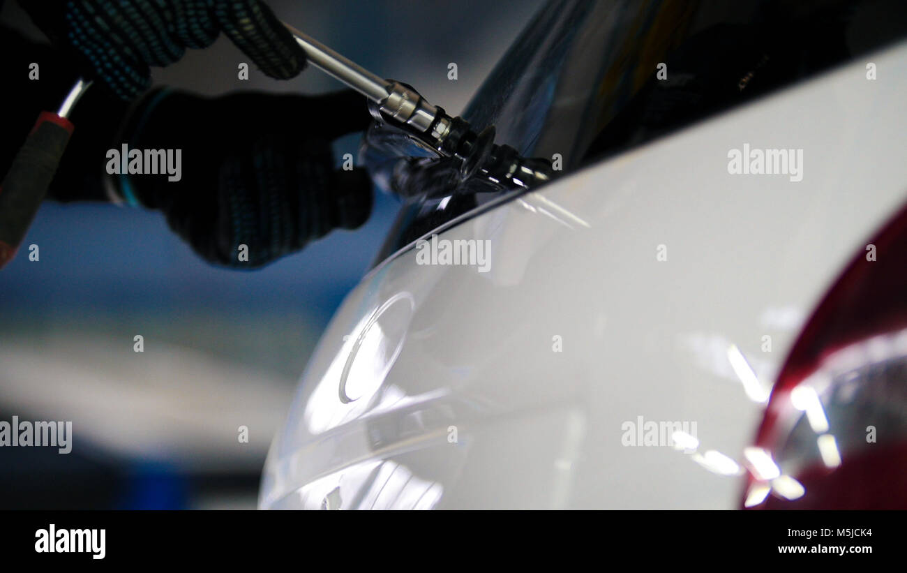 Car mechanic screwing pin wipers of automobile in service Stock Photo ...