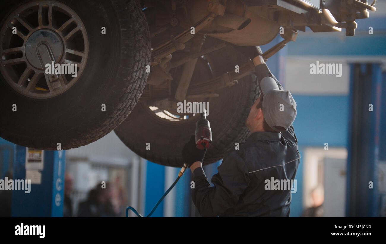 Mechanic is checking the wheel in garage automobile service Stock Photo ...