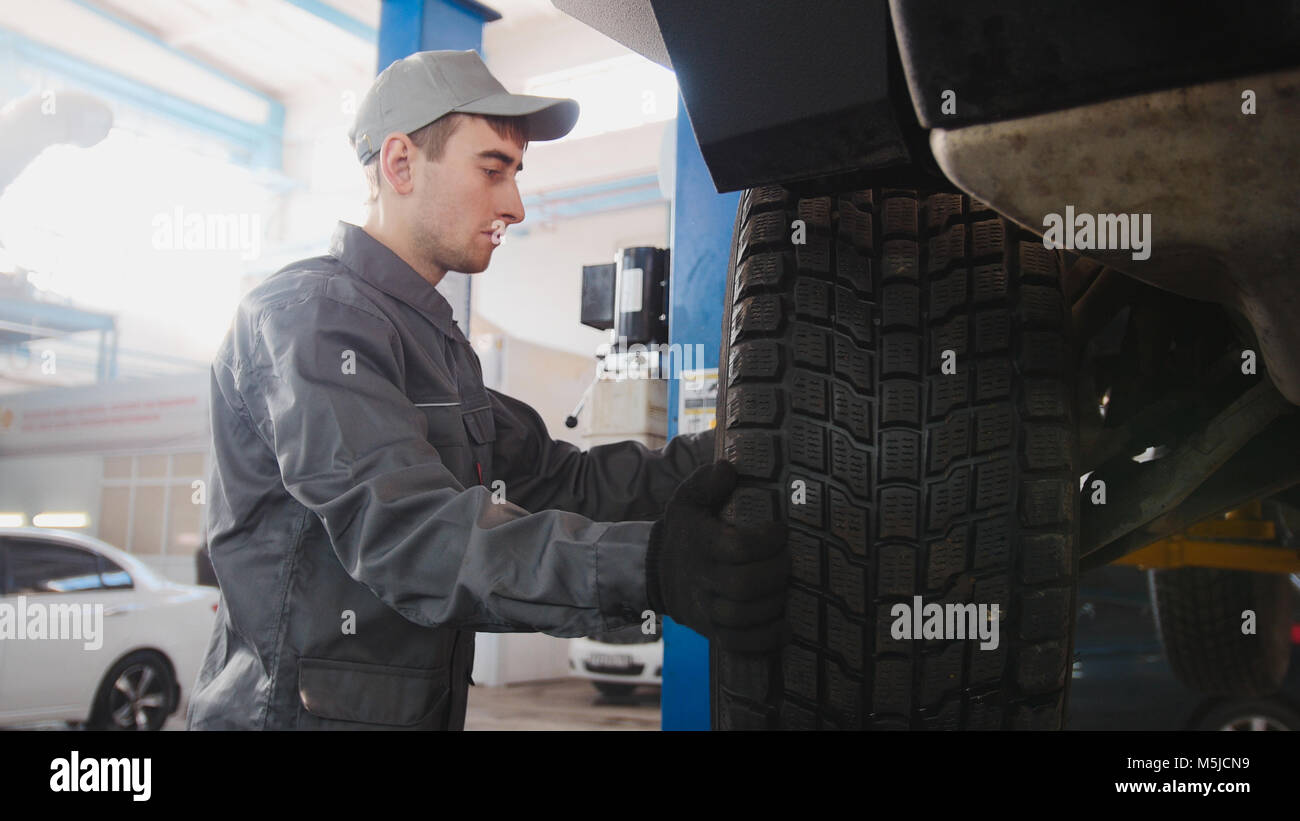 Garage automobile service - a mechanic working the wheel, close up ...