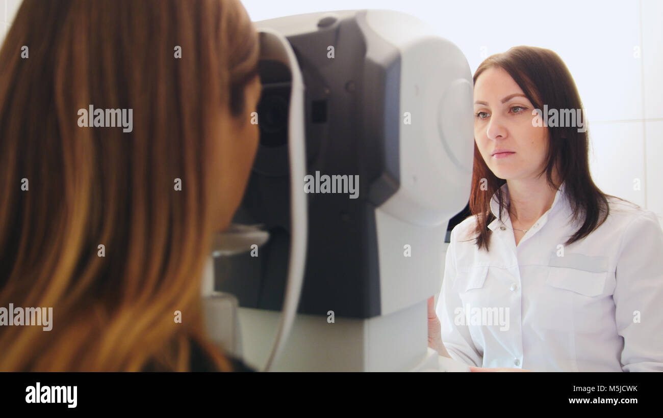 Ophthalmology clinic - optometrist checks patient's vision by modern ...