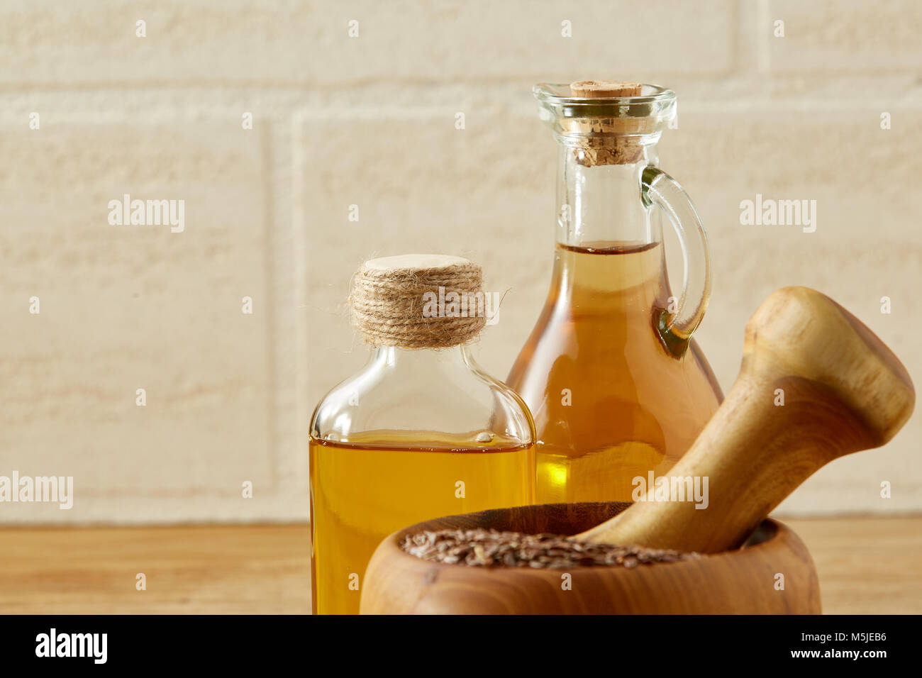 Beautiful composition of two transparent glass oil jars, wooden mortar ...