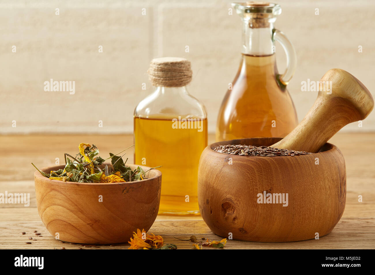 Beautiful composition of two transparent glass oil jars, wooden mortar ...