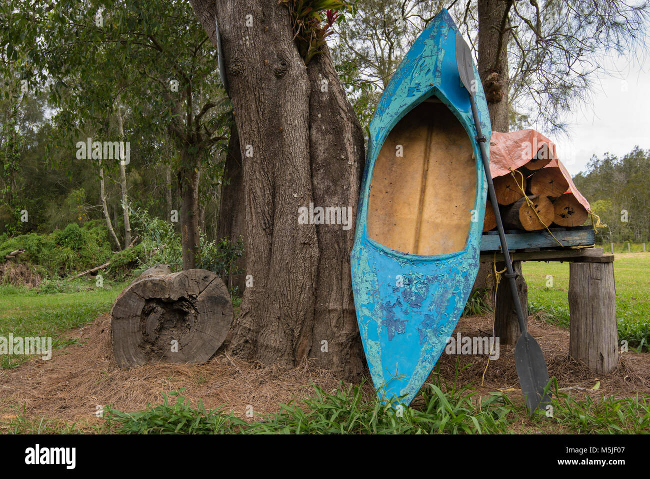 A Kayak and stacked firewood on a property beside Warrell Creek that ...