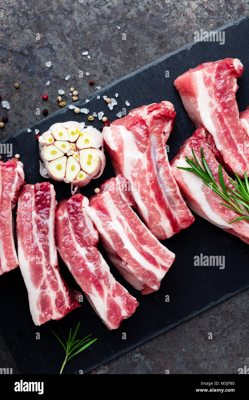 Raw uncooked pork ribs, fresh meat on dark metal background. Top view ...