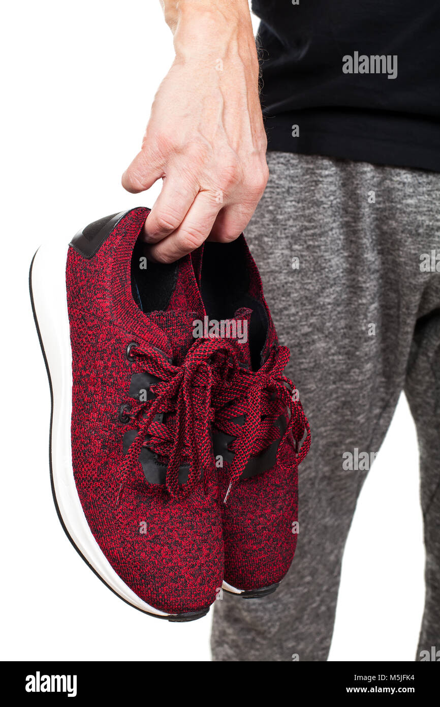 Close up picture of man holding stylish sporty shoes on isolated ...