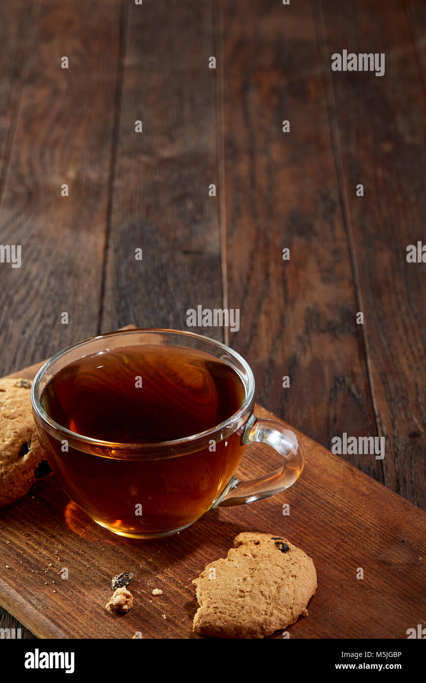 A transparent glass cup of tea with delicious chocolate chips cookies ...