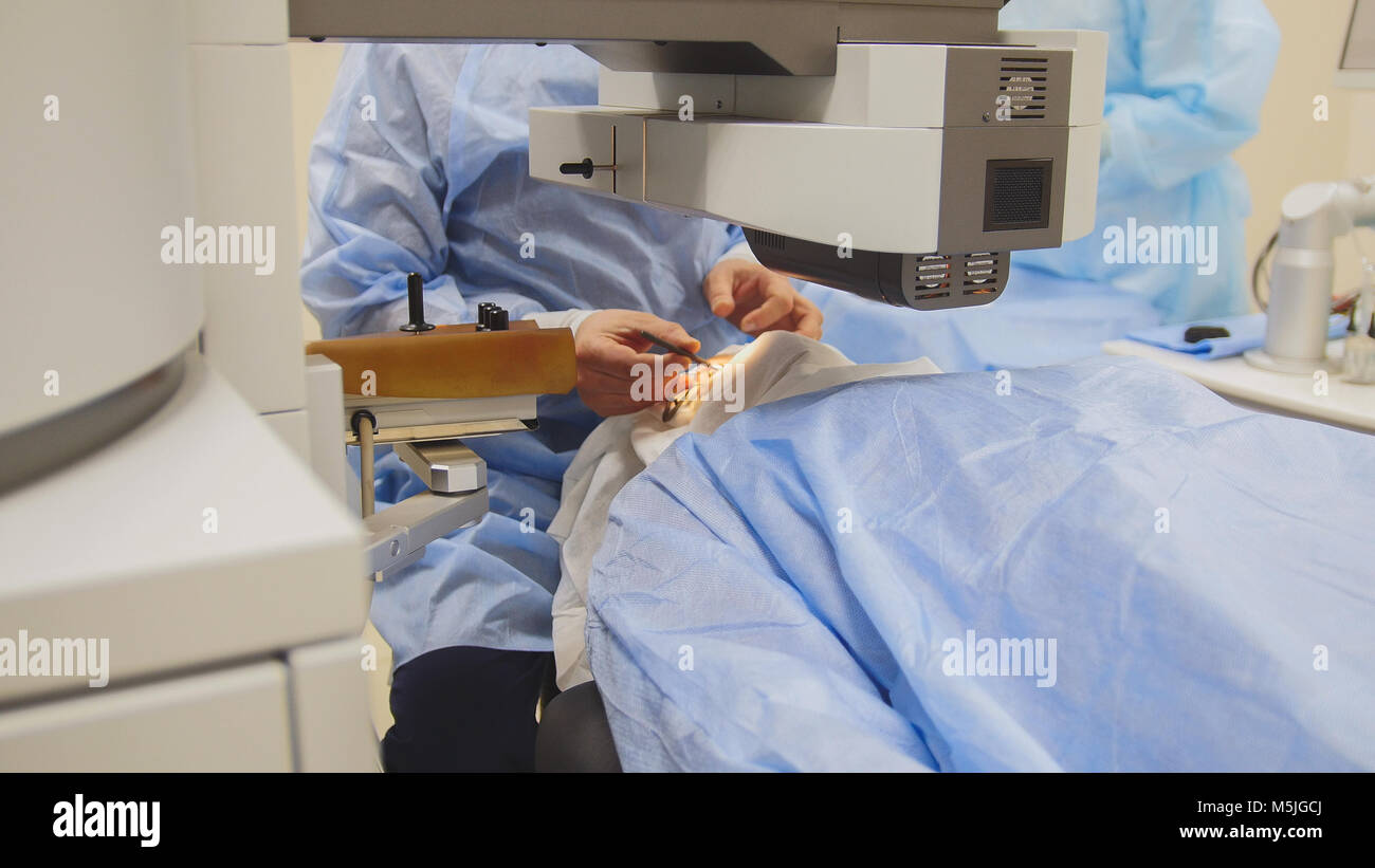 The patient lies on the operating surgical table during ophthalmology ...
