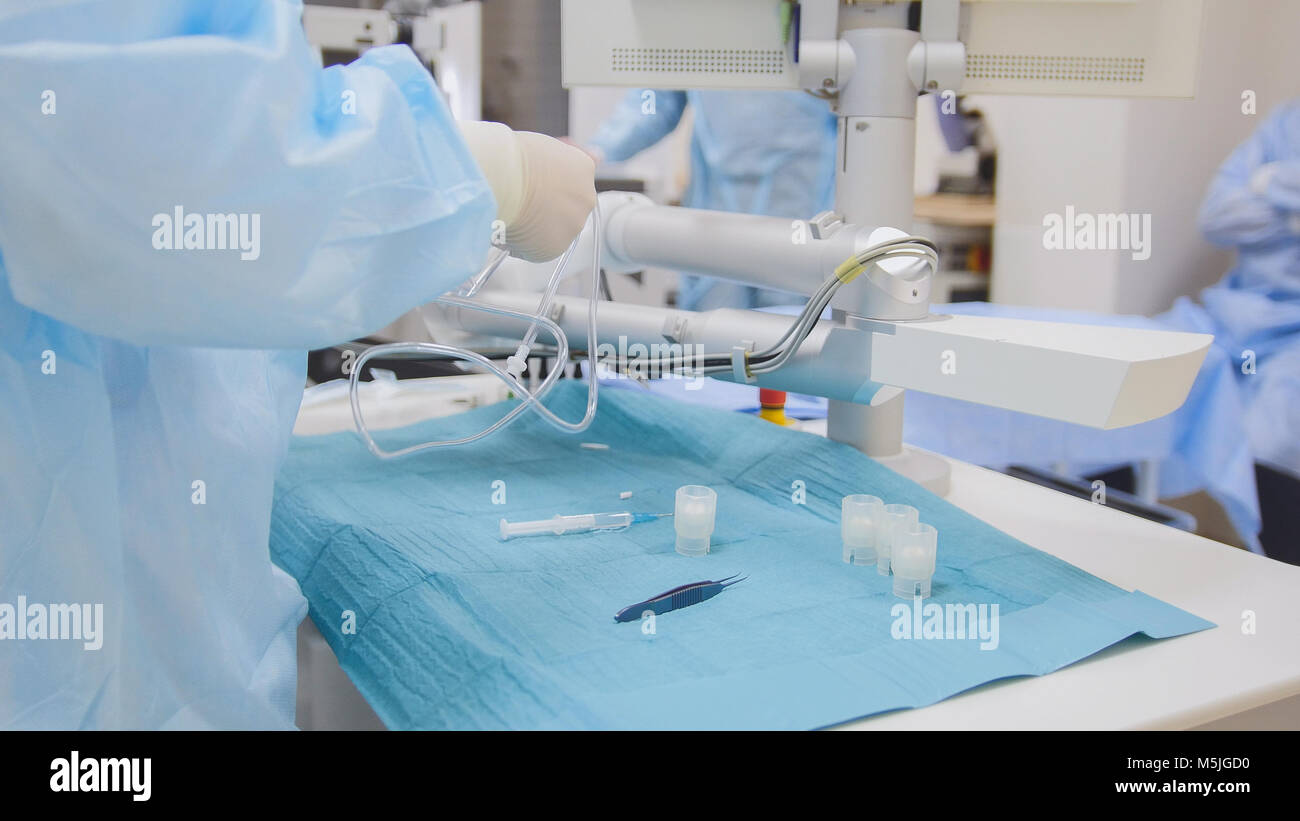 Surgeons and assistants prepare for surgery in an operating room ...