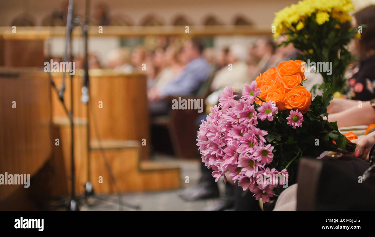 Audience in the concert hall holding flowers for artists on stage Stock ...