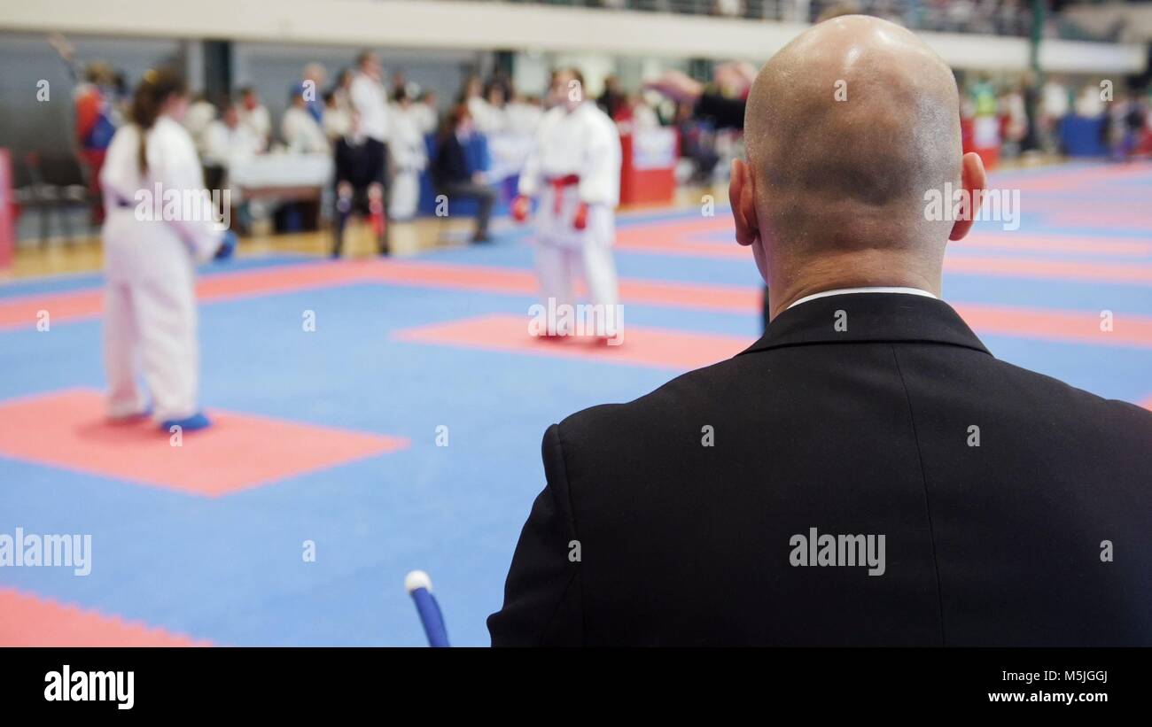 Martial art competitions - bald man coach-judge looking at karate ...