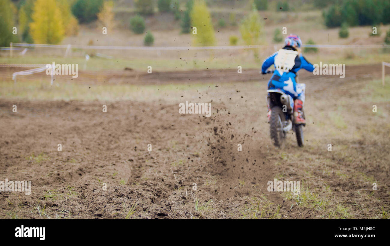 Motocross racer start riding his dirt Cross MX bike - rear view Stock ...