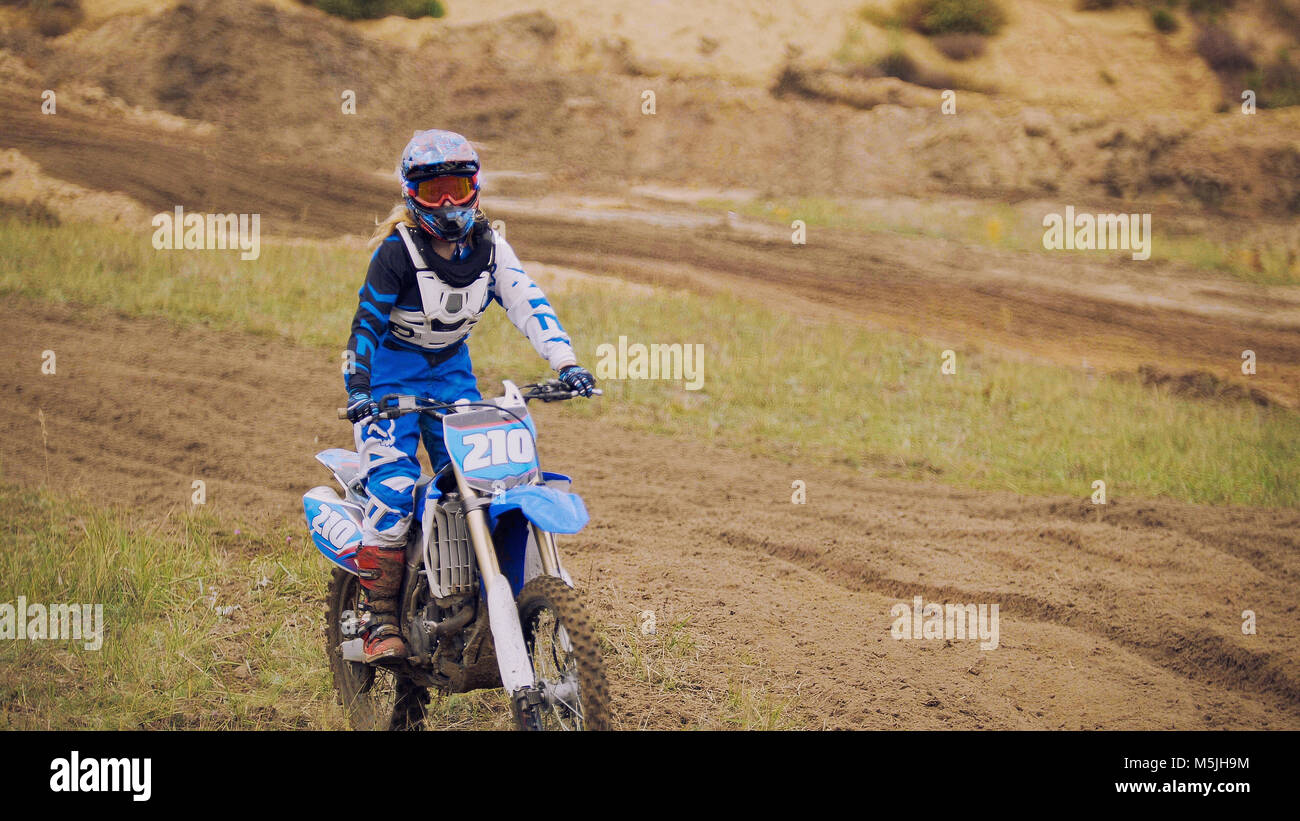 Young woman mx biker - motocross racer on dirt bike at sport track ...