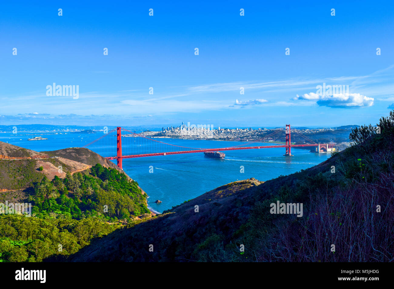 Container ship passes Golden Gate Bridge, view from the hills, San ...