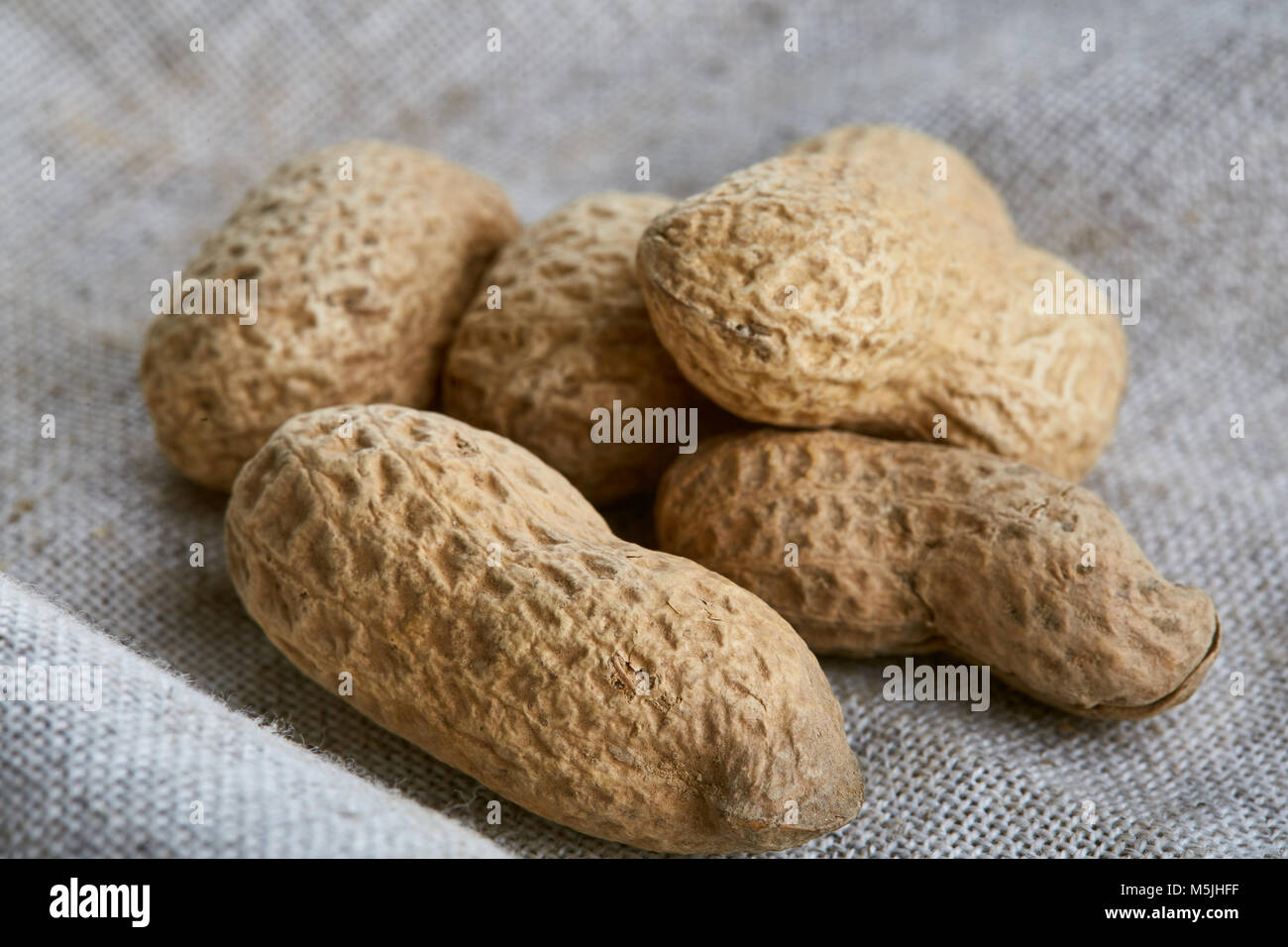 Top view close-up picture of heap of peanuts on light grey fabric ...