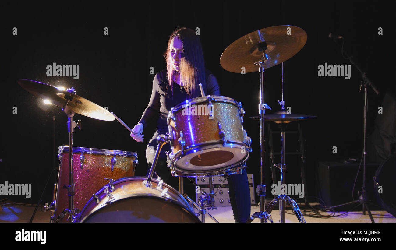 Emotional girl drummer, attractive youngblack hair model plays the ...