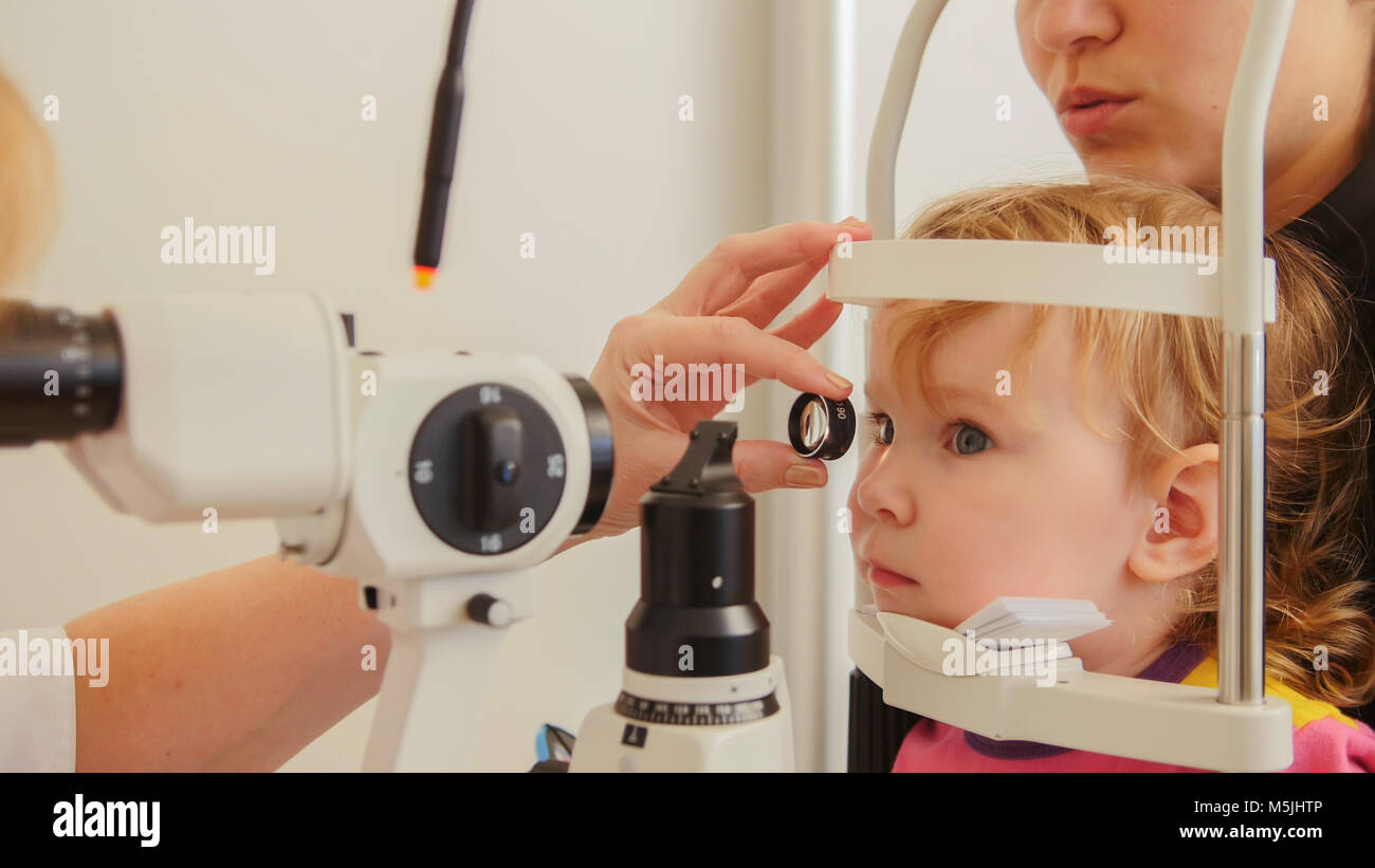 Child's ophthalmology - doctor optometrist checks eyesight at little ...