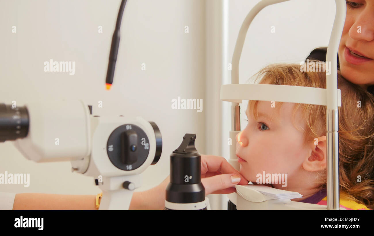 Child's optometry - little girl hecks eyesight in eye ophthalmological ...