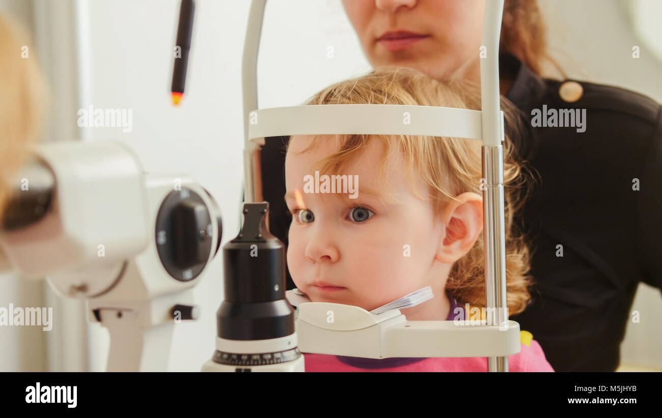 Child's optometry - little girl hecks eyesight in eye ophthalmological ...