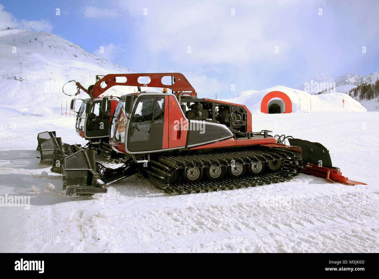 An amazing view of a snowcat in the snow at the top of a ski piste in ...