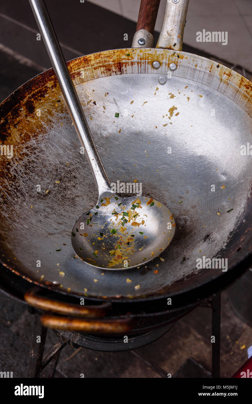 A spoon and wok with some dried-on food Stock Photo - Alamy