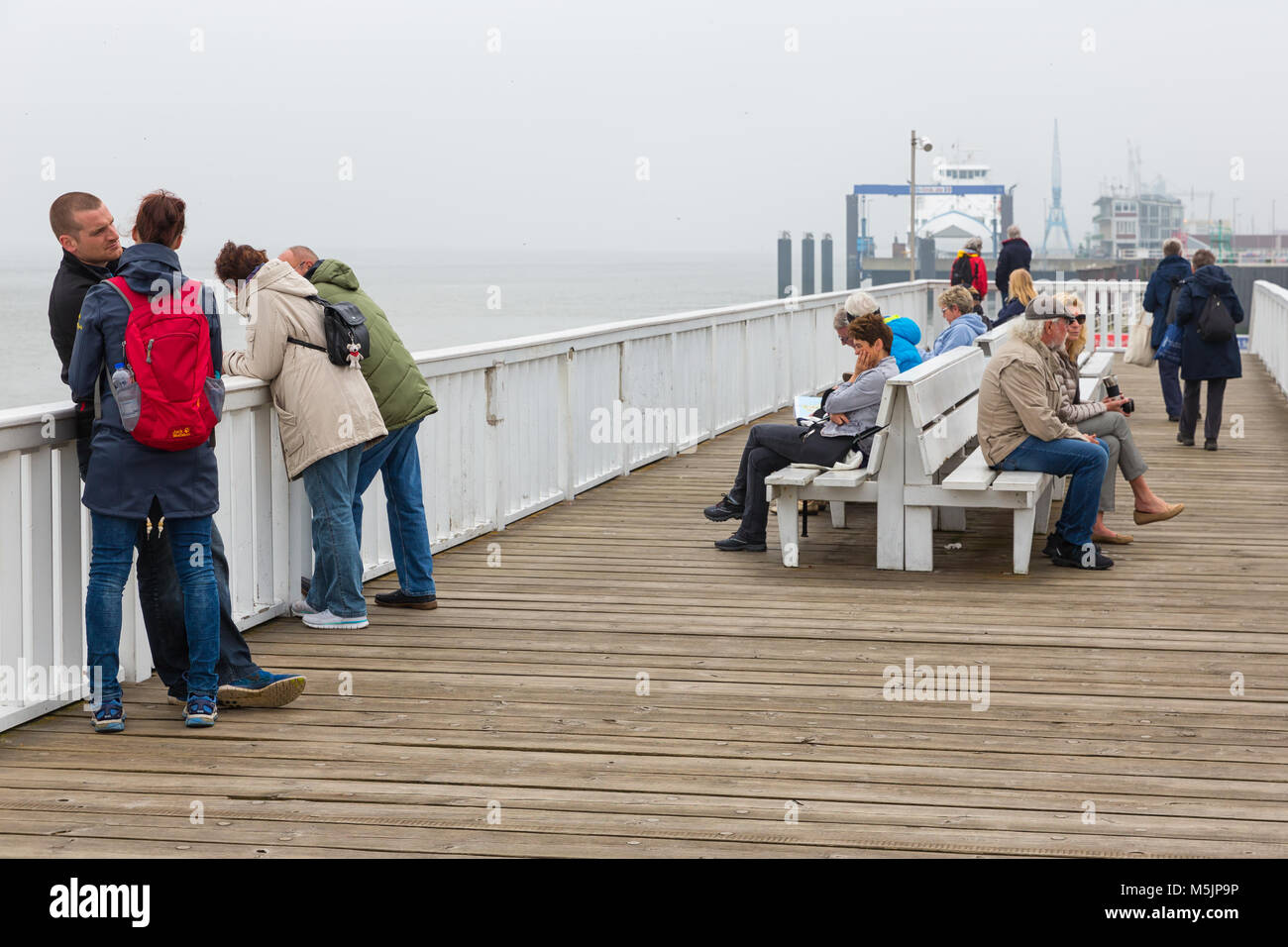 People at wooden pier Cuxhaven waiting for ferry to Helgoland Stock ...