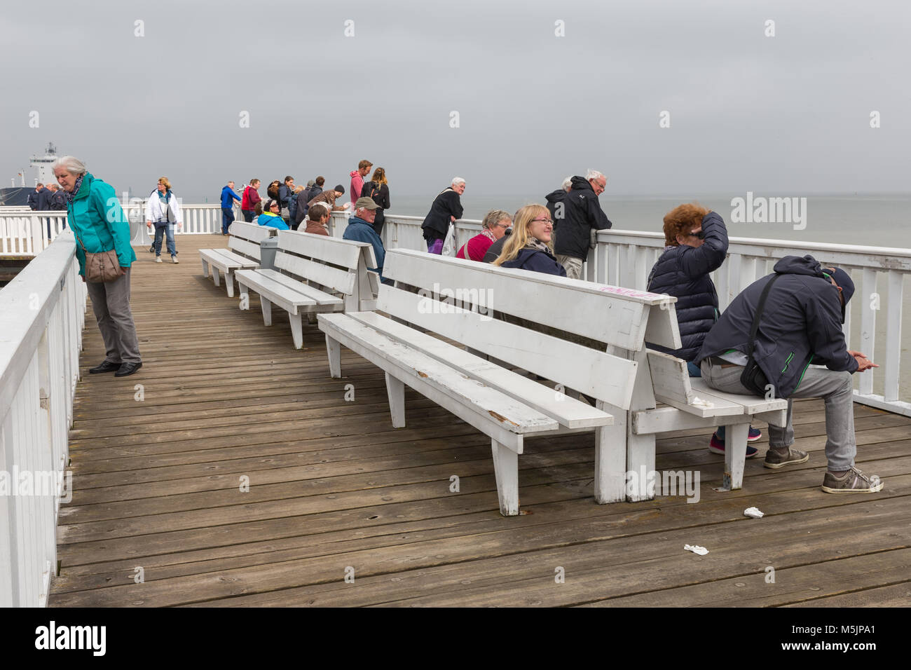 People at wooden pier Cuxhaven waiting for ferry to Helgoland Stock ...