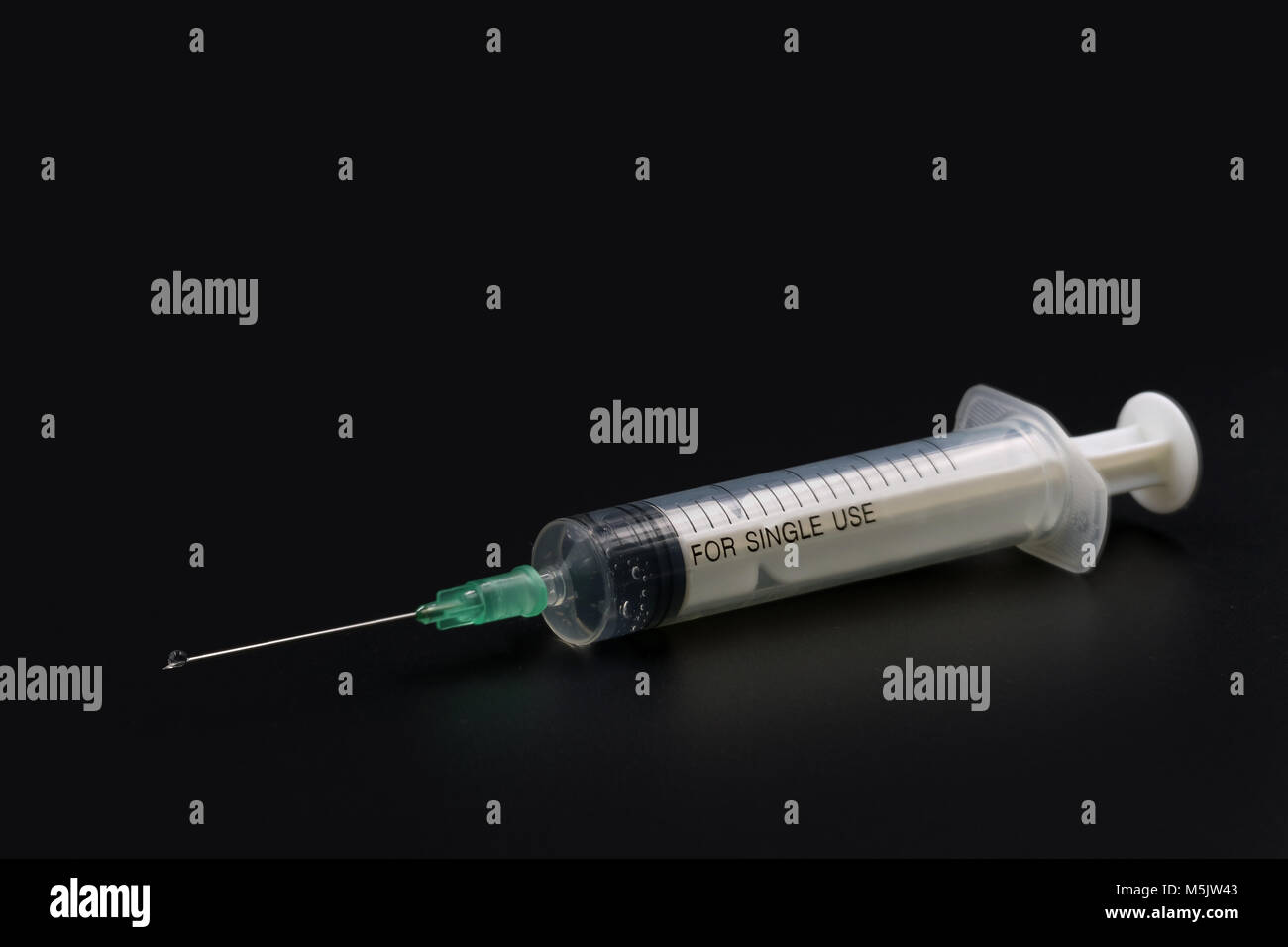Plastic syringe close-up isolated on black background Stock Photo - Alamy