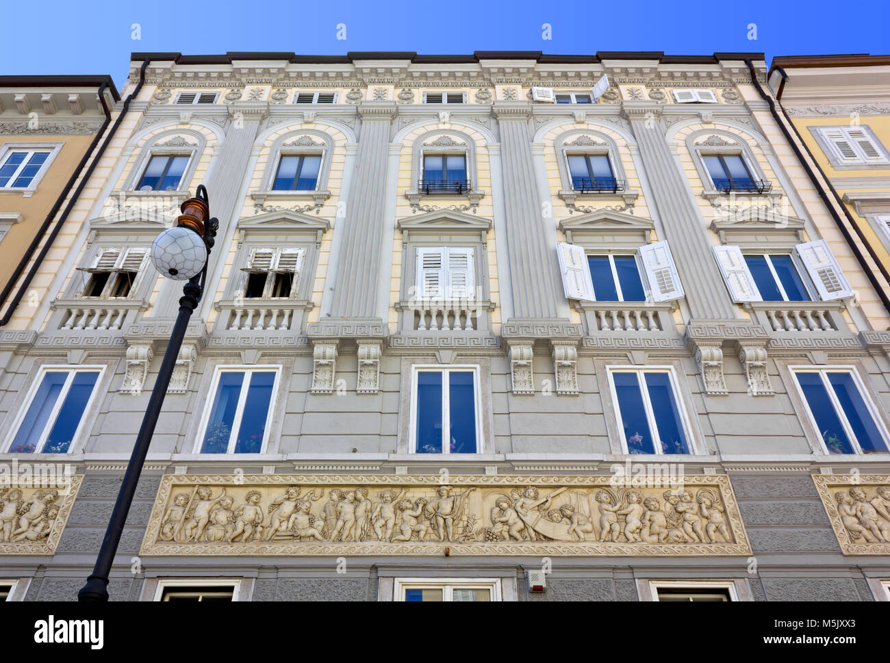 Decorated facade of a neoclassical palace in Trieste, Italy Stock Photo ...