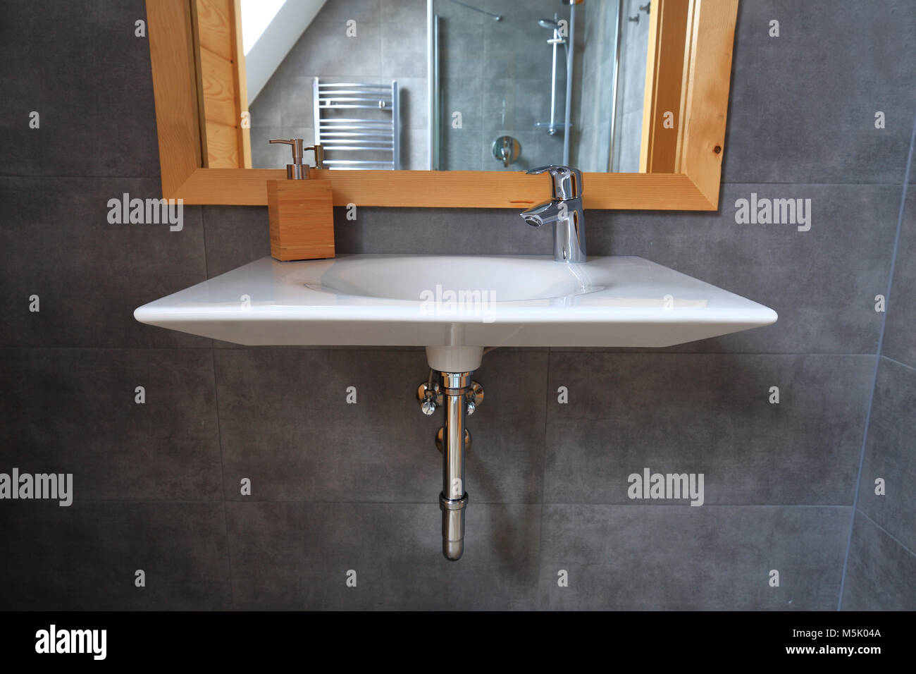 New shiny flat wash basin on gray tile background with mirror. Elements ...