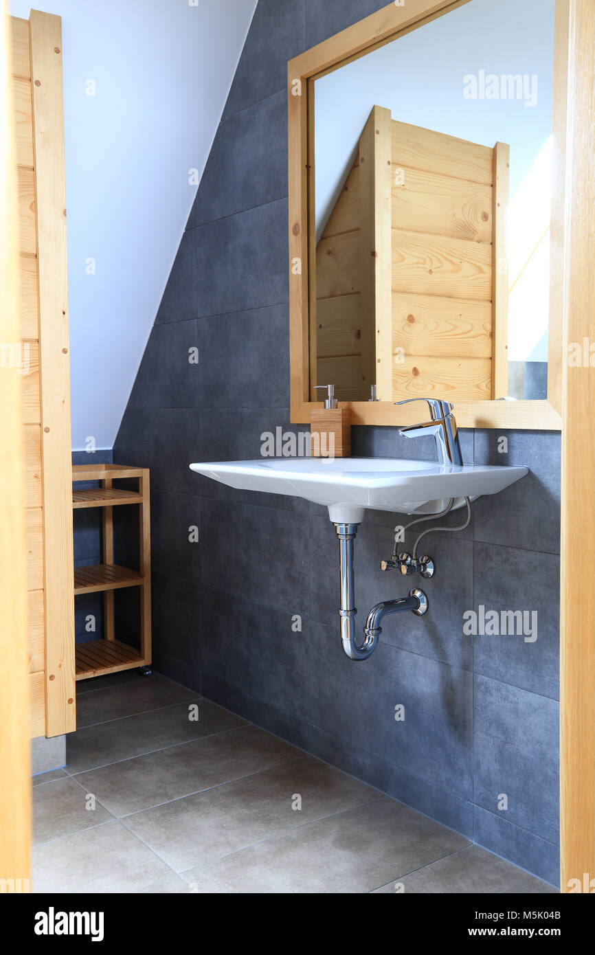 View through open entrance to bathroom. Wash basin mirror and wooden ...