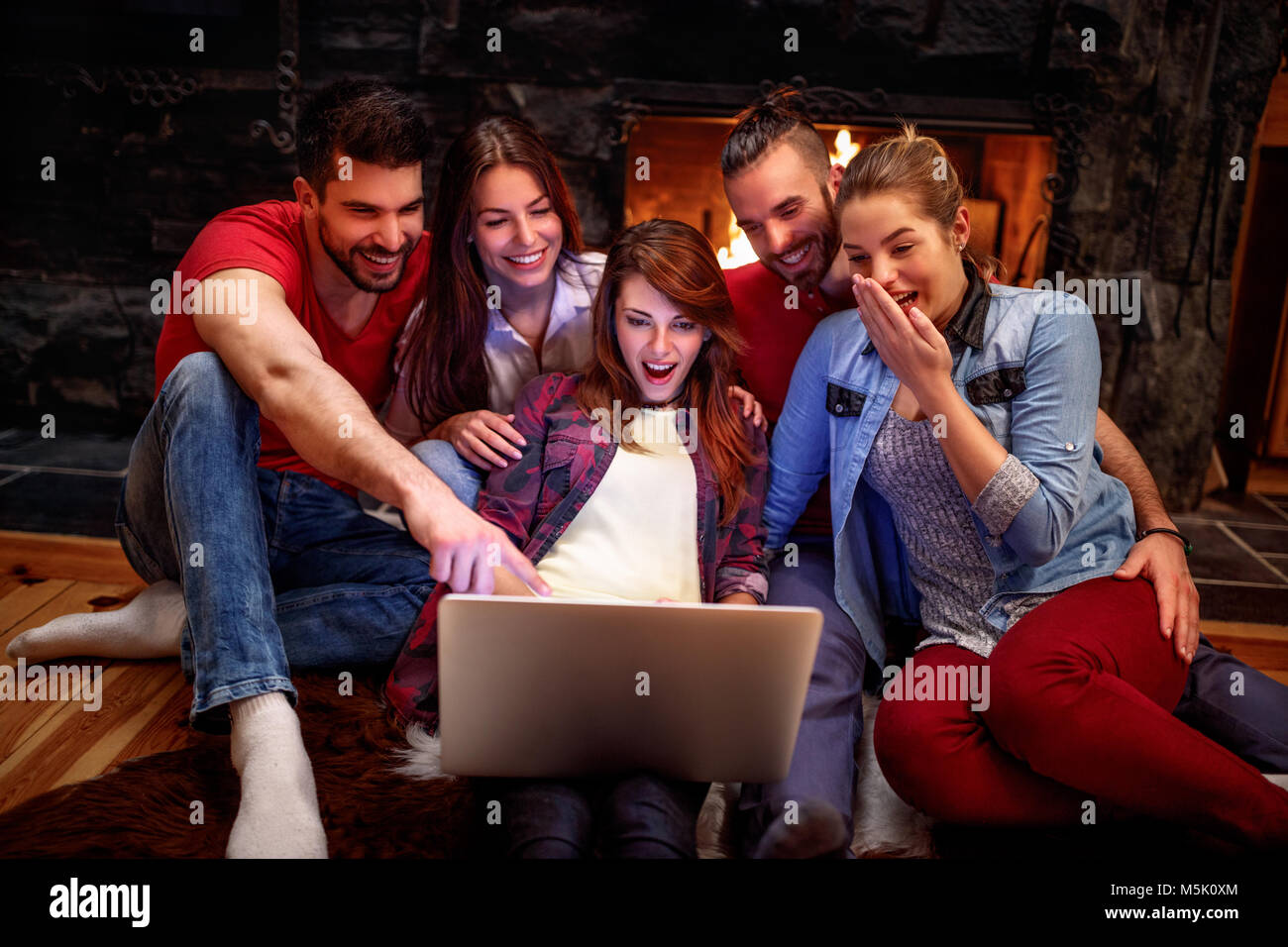 Group of friends having fun watching movie together on laptop at home ...