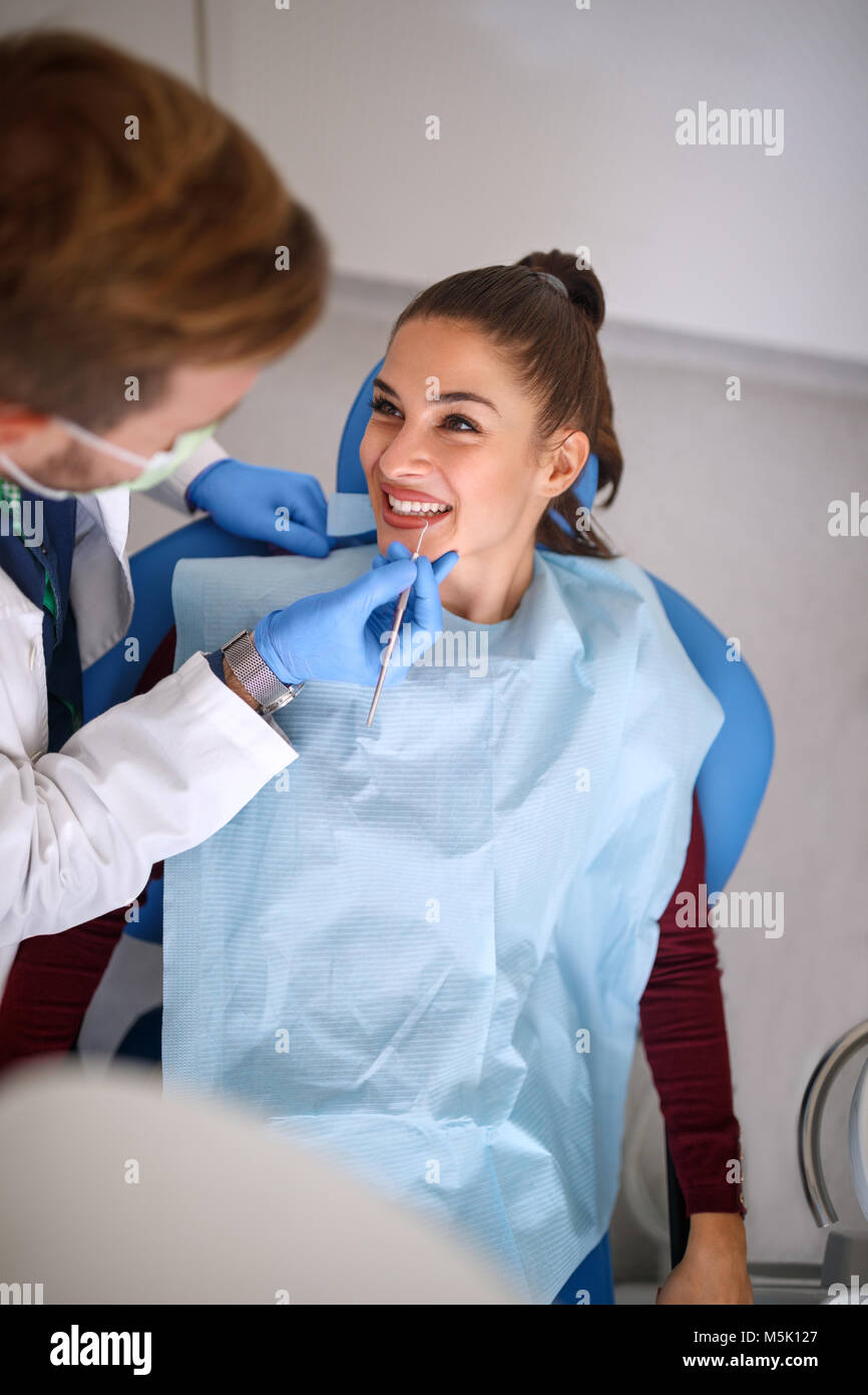 Smiling female patient showing beautiful teeth to dentist Stock Photo ...