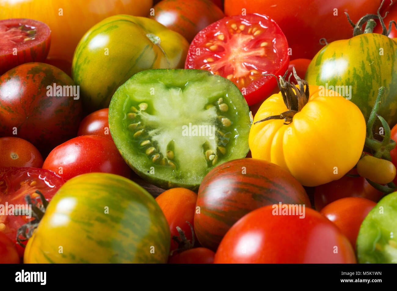 Colorful tomatoes, some sliced, shot from above Stock Photo - Alamy