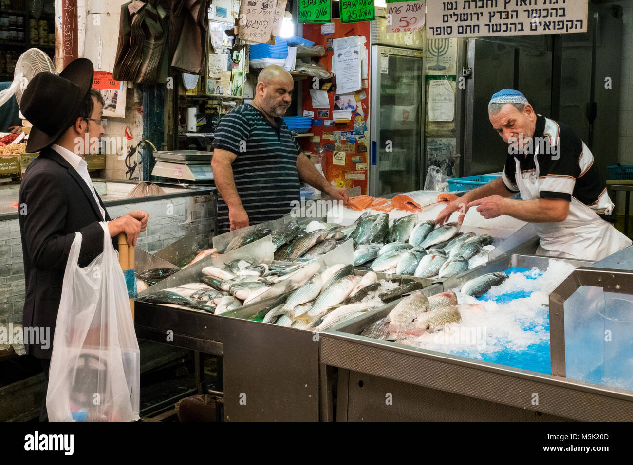 A man buying fish on a stall at the Mahane Yehuda Market at Jerusalem ...
