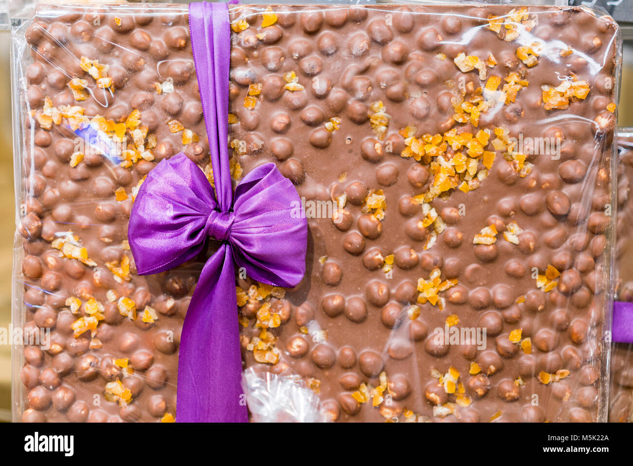 A huge chocolate bar tied with a ribbon. Sweet gift. Milk chocolate ...