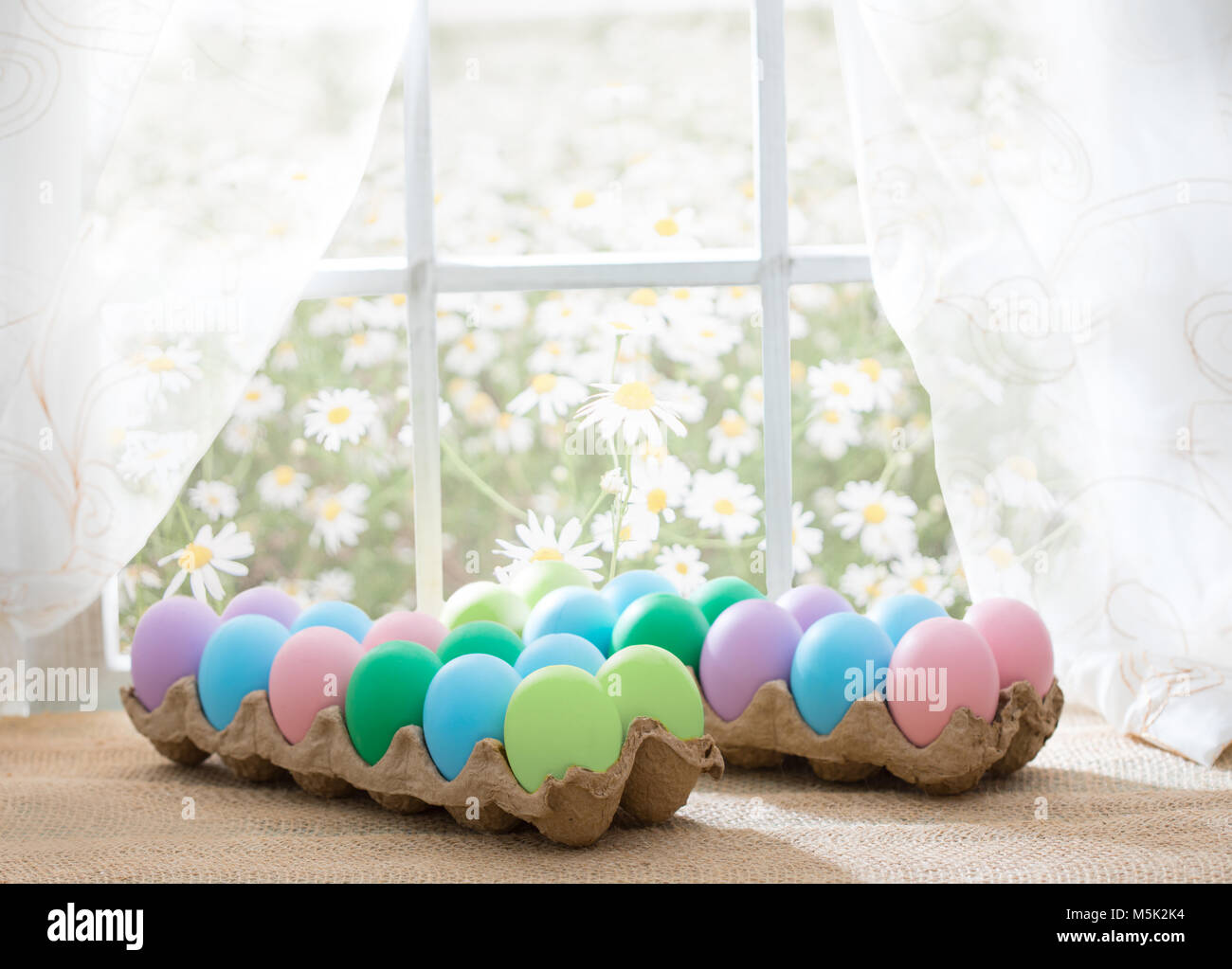 Easter shopping theme: colorful eggs in an egg crate on the window in a ...